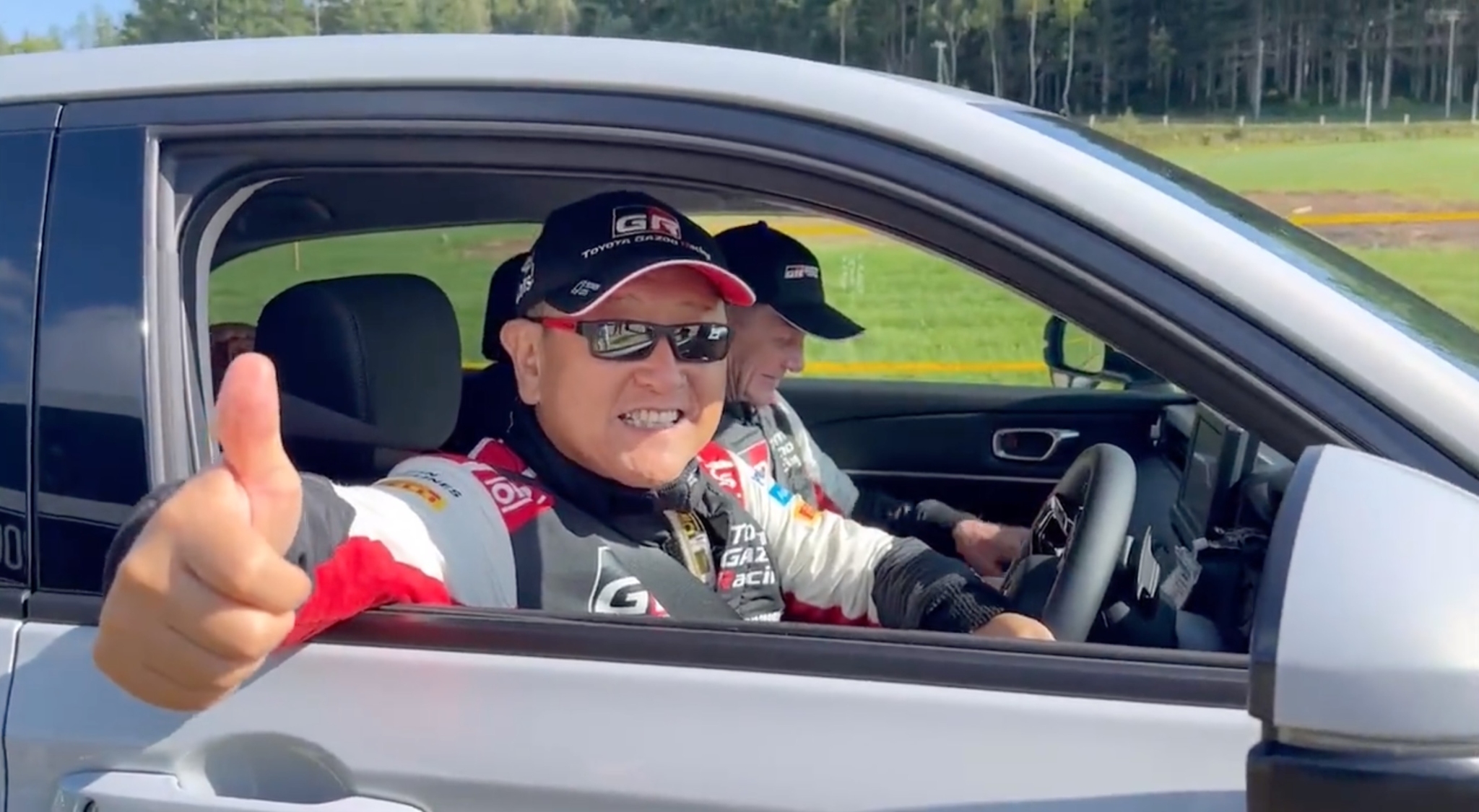 Chairman Akio Toyoda gives thumbs up from behind the wheel of a Honda ...